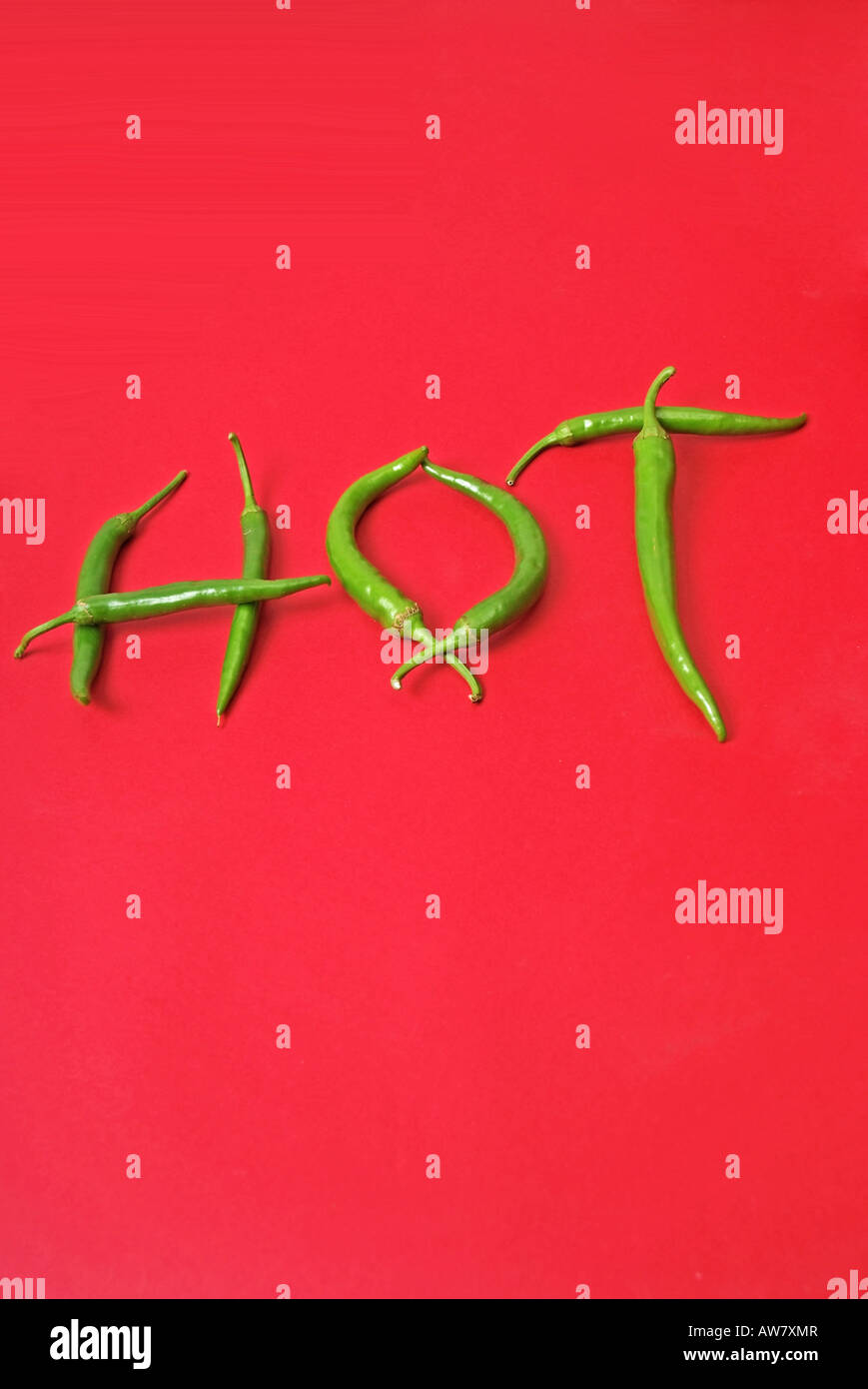 Hot in letters formed with Green Chilli on red background Stock Photo ...