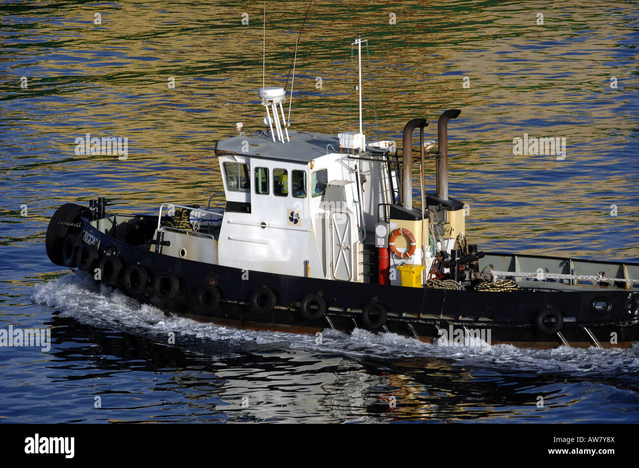 A small fishing boat passes a large container ship on a beautifull ...