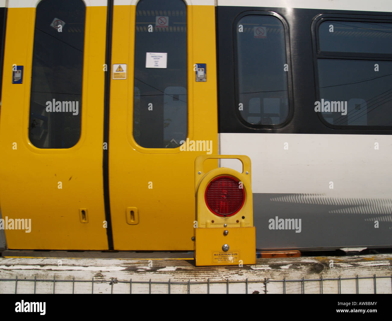 modern commuter train passing level crossing lamp Stock Photo - Alamy