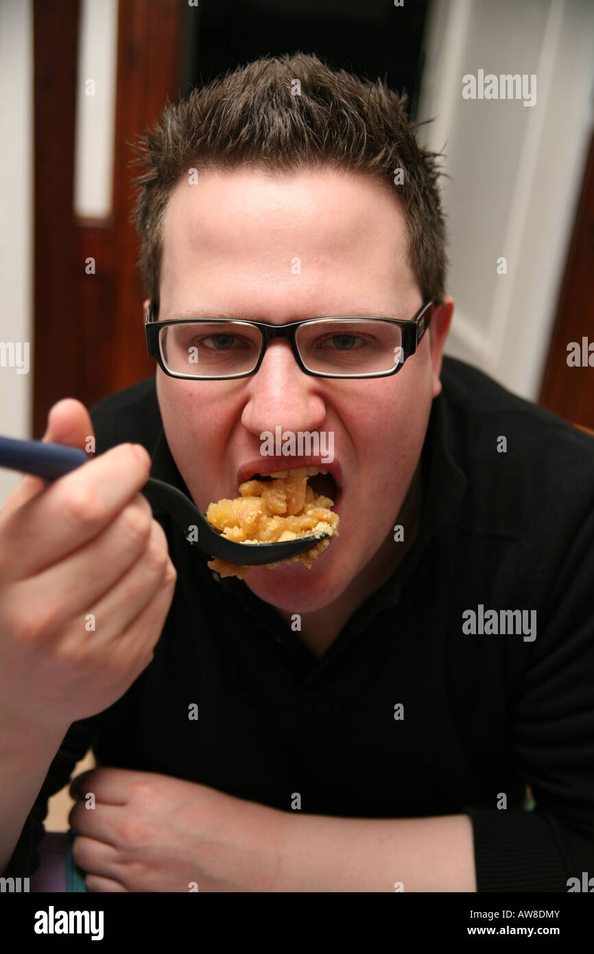 Man eating apple crumble Stock Photo - Alamy