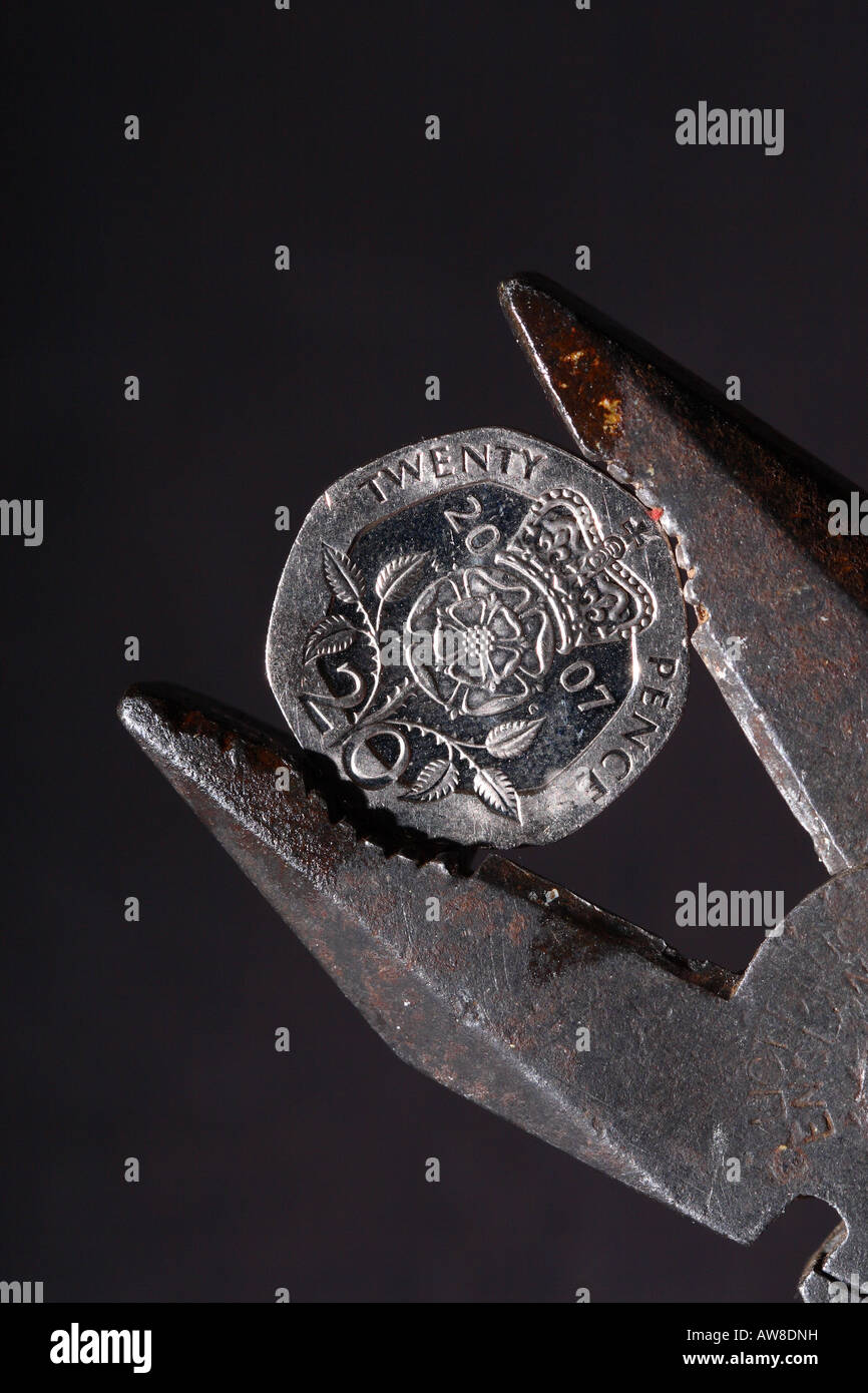 British money 20p 20 pence coin being held squeeze by plier tool ...