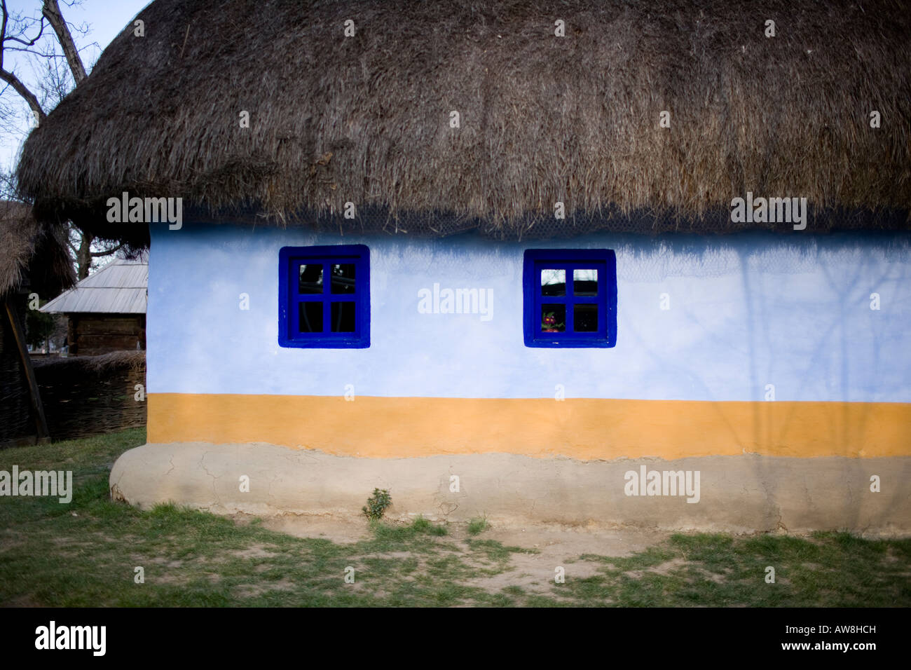 old cottage house with blue window frame and white front part decorated ...