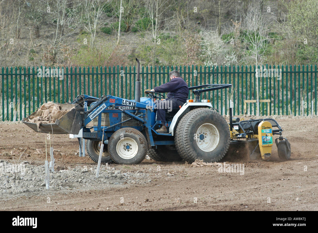 tractor bulldozer being used to collect rubble and flatten the ground ...