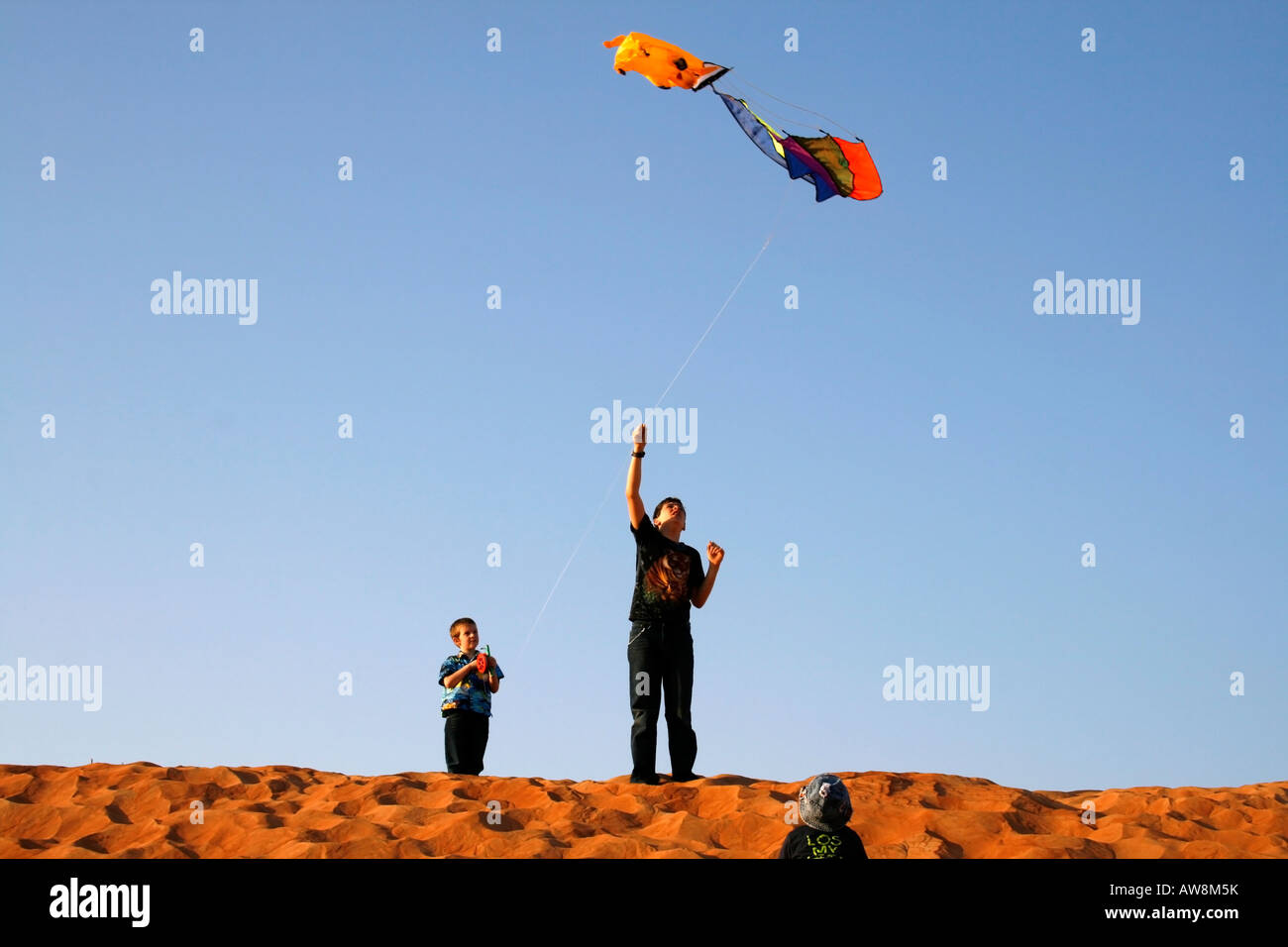 Two Brothers flting a kite in the desert in the United Arab Emirates ...