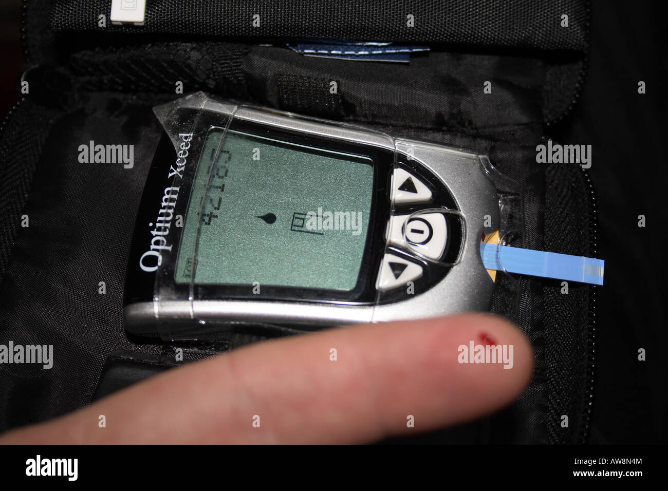 Diabetic blood sugar meter and pin prick of blood on index finger Stock ...