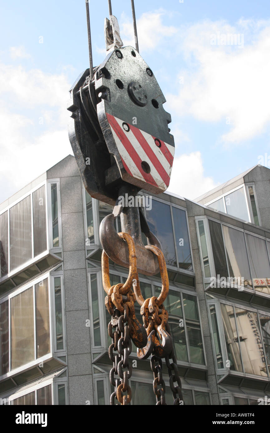 Crane block and chains during lift in central London, outside offices ...