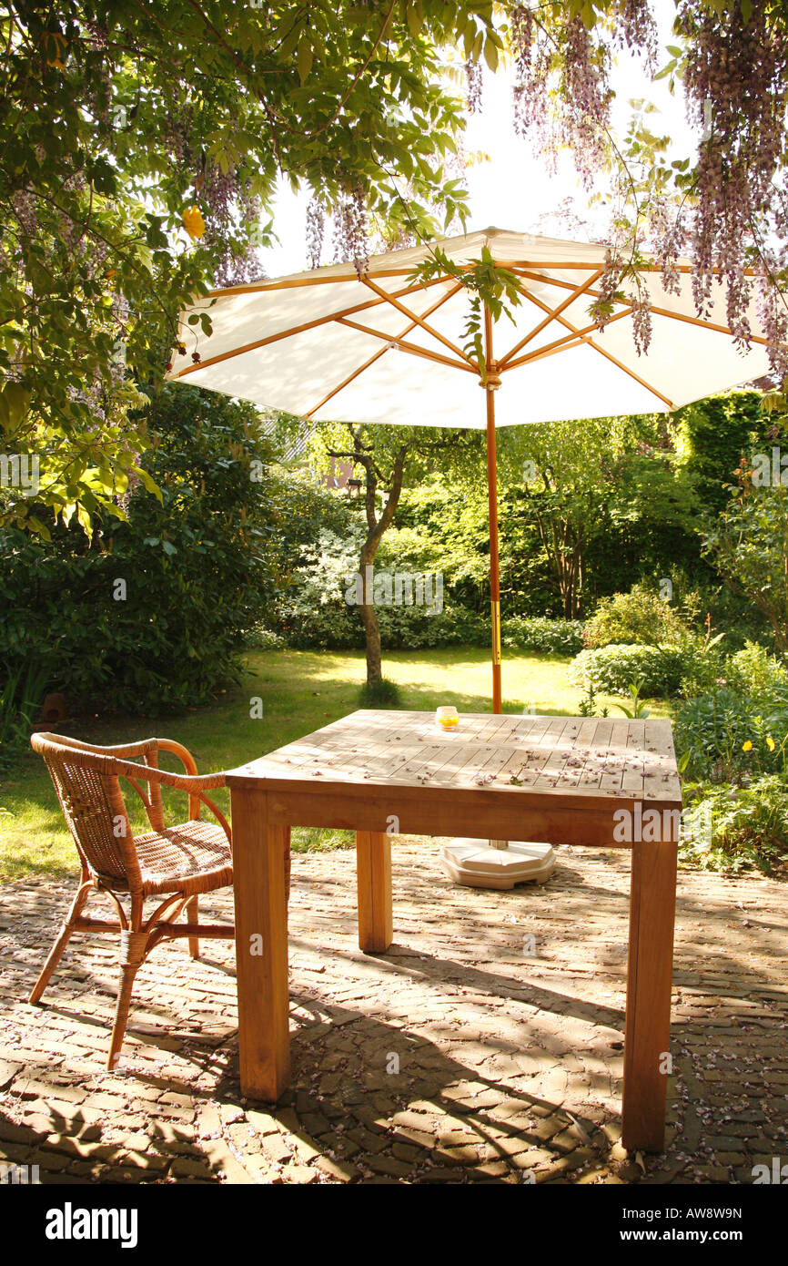 Garden scene with table chair and parasol on a summer day Stock Photo ...