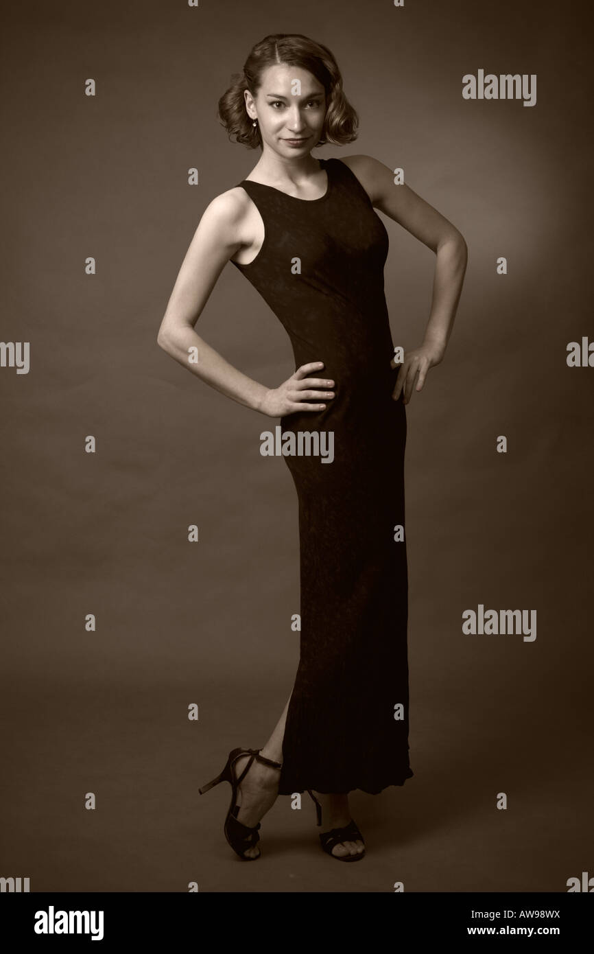 Full body of young pretty brunette woman modelling long black dress ...