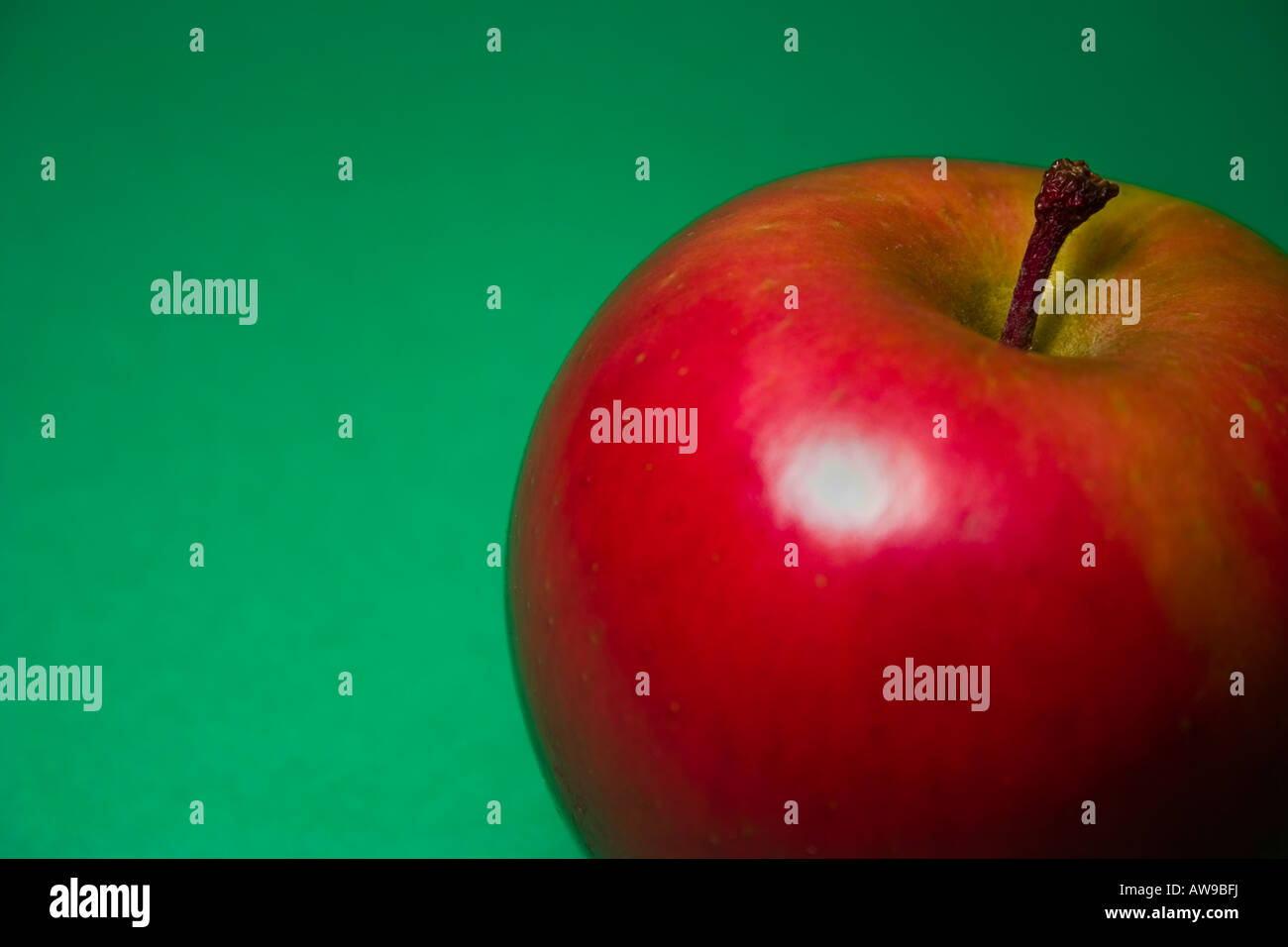 Red Apple on green background Stock Photo - Alamy