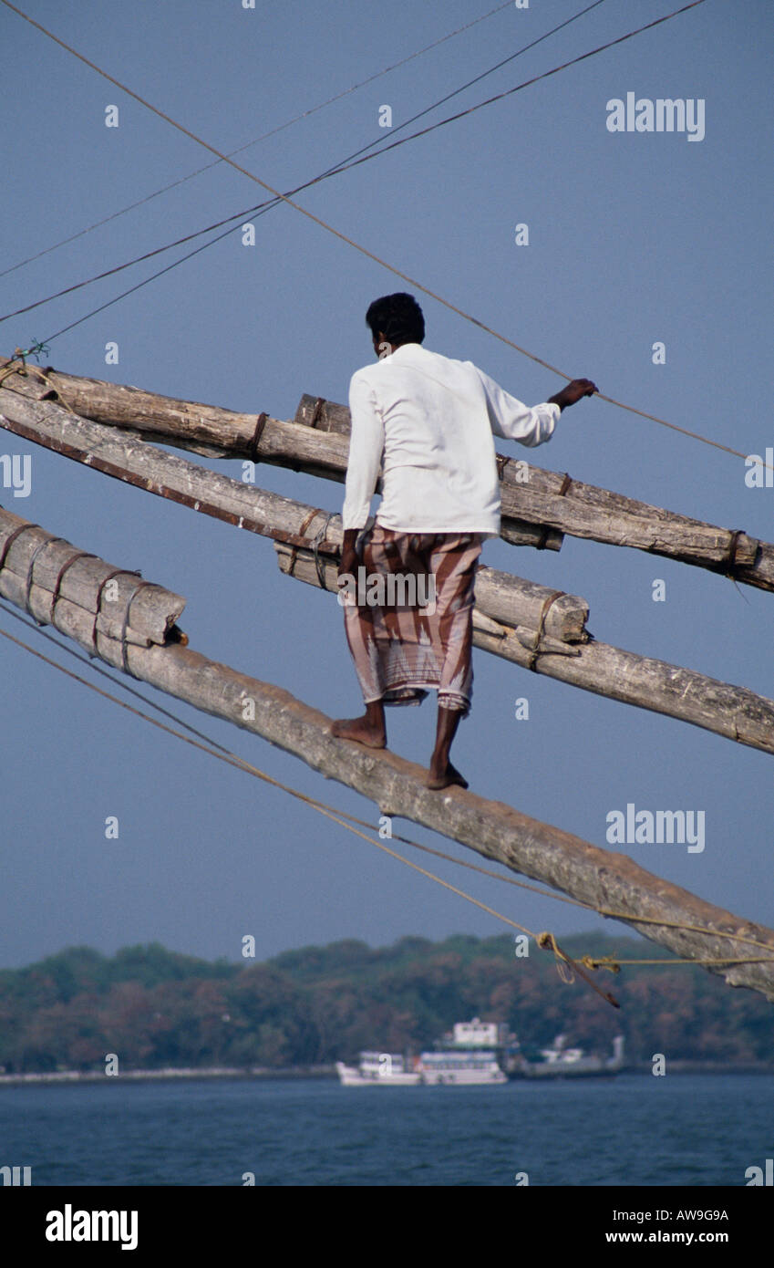 Fisherman on a Chinese fishing net ('Cheena vala'), Fort Cochin, Kerala ...