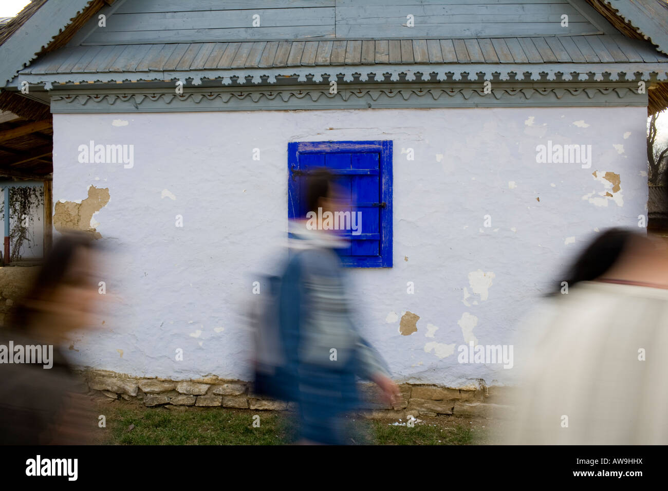 part of a white cottage house with a closed blue wooden window and ...