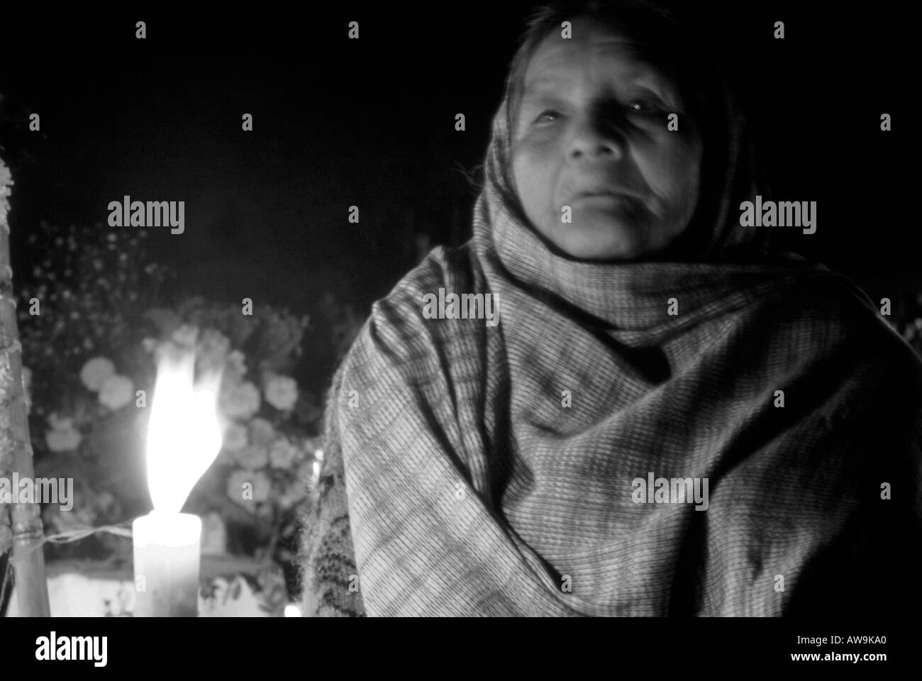 Old woman celebrating Day of The Dead at grave of relative in cemetary ...
