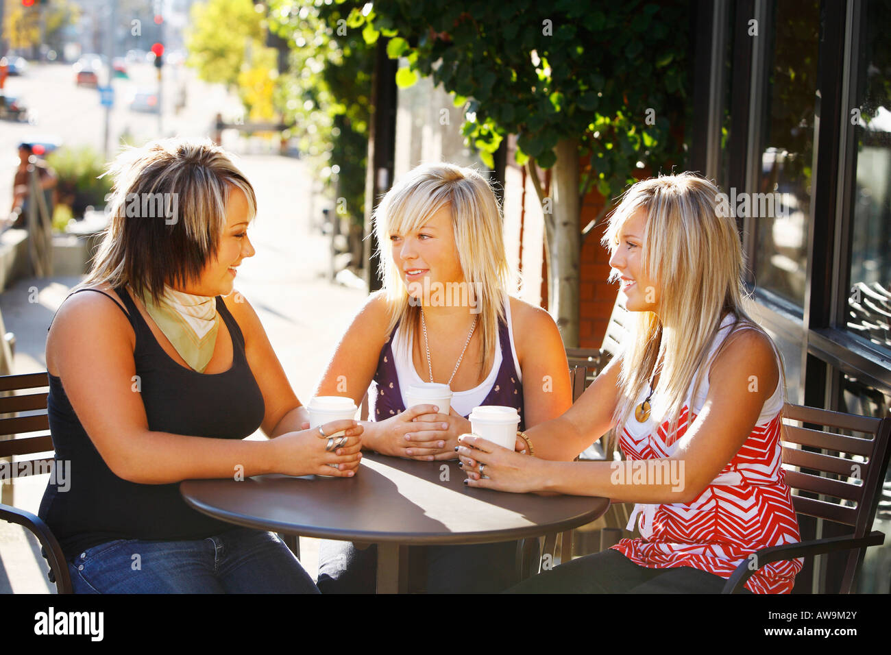 Three young girls talking together Stock Photo - Alamy