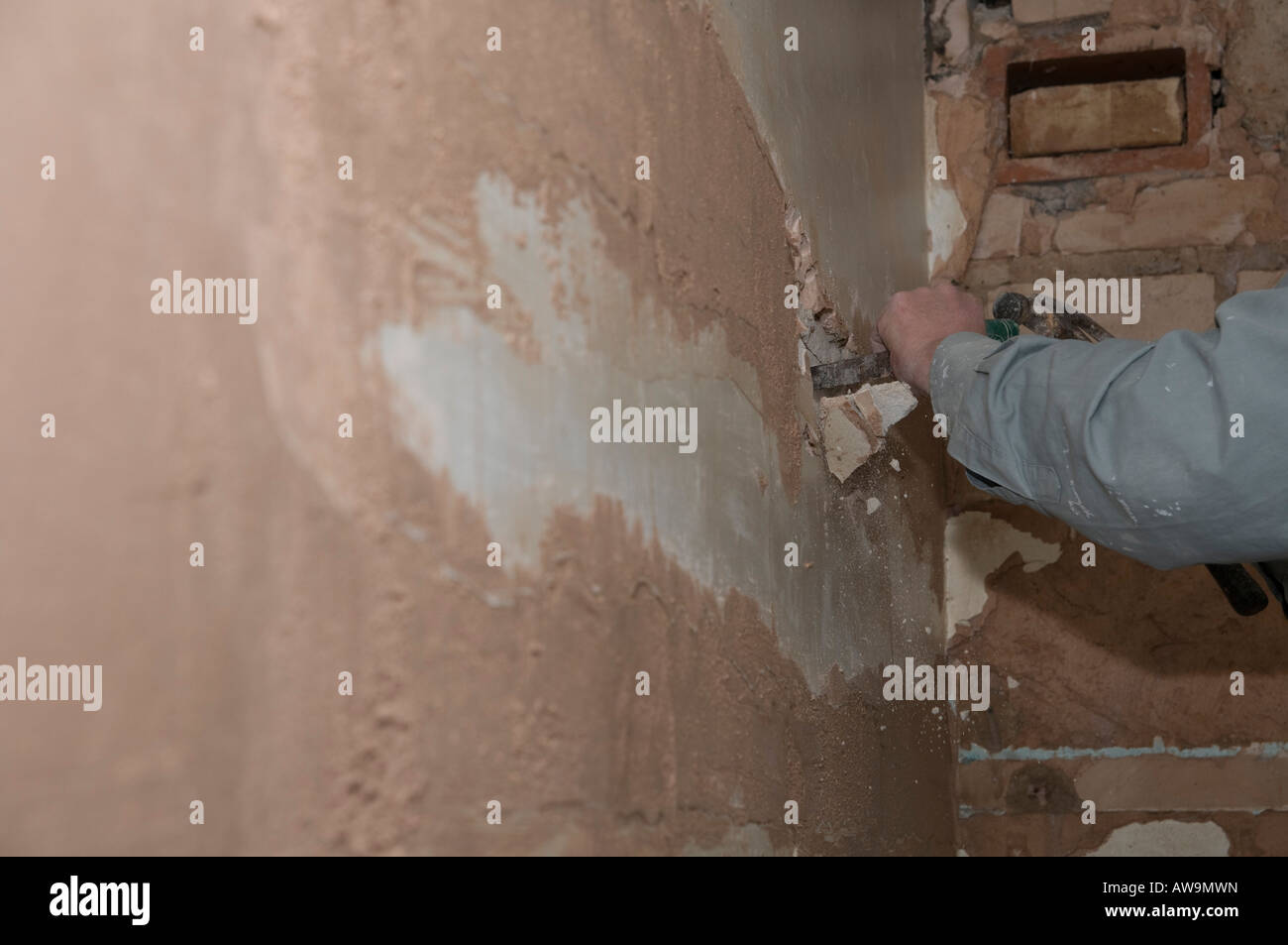 chopping out loose plaster Stock Photo - Alamy