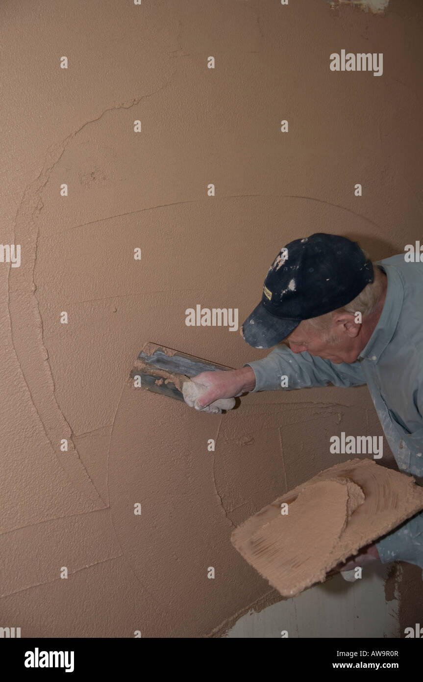 trowelling plaster onto wall (Thistle bond Stock Photo - Alamy