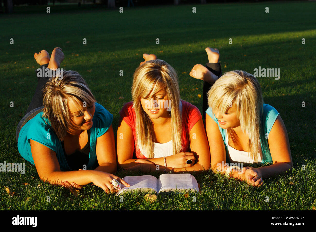 Three girls reading the Bible Stock Photo - Alamy