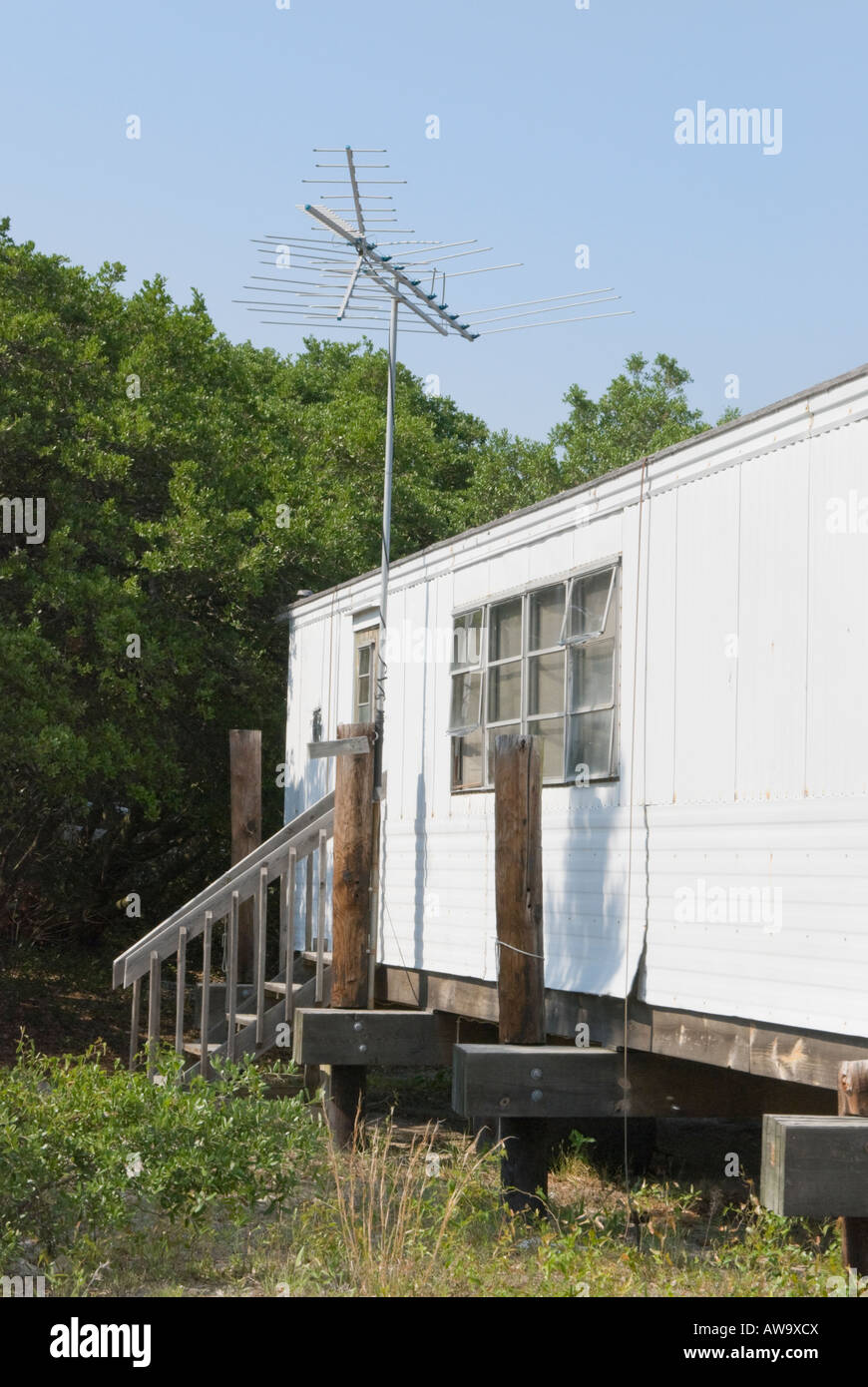 White mobile home trailer house with TV antenna, affordable housing in ...