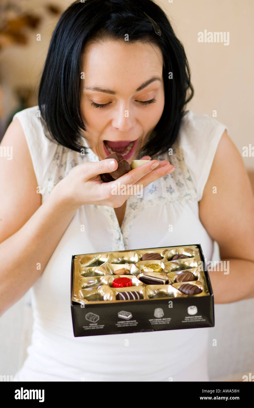Woman eating chocolates hi-res stock photography and images - Alamy