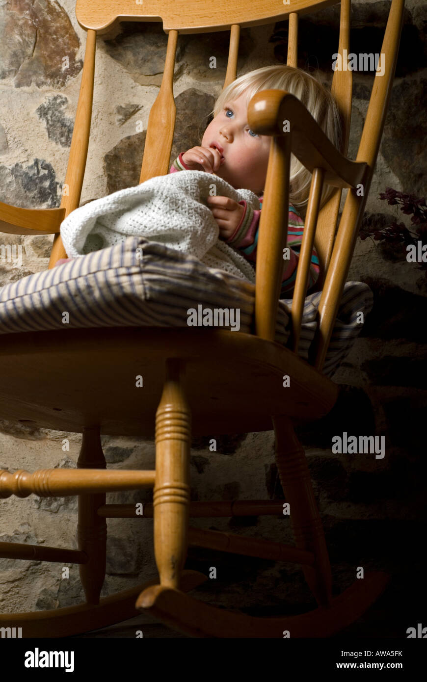 Image of a two year old girl sitting in a rocking chair with her ...