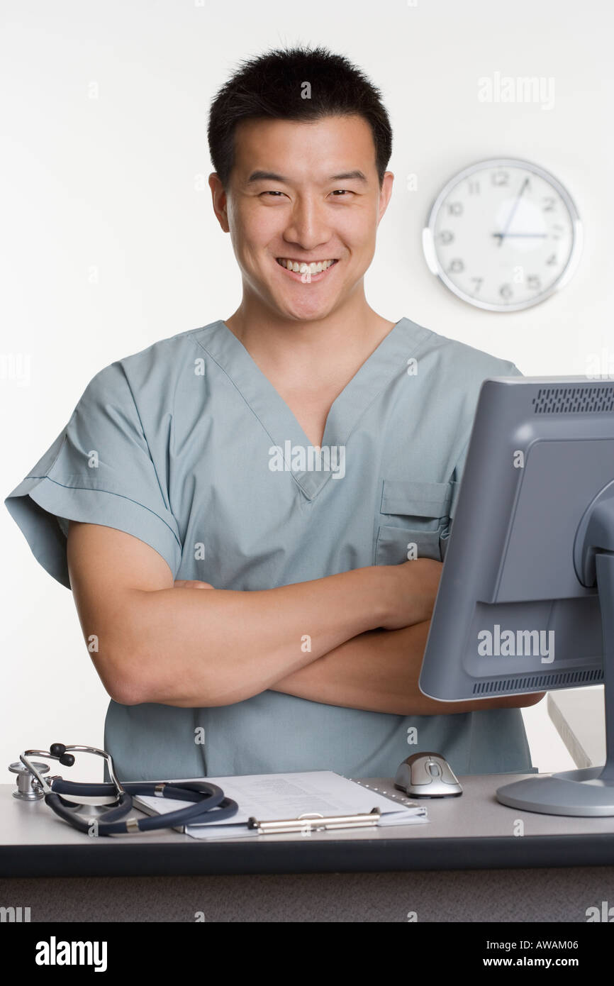 Male healthcare worker standing at desk Stock Photo - Alamy