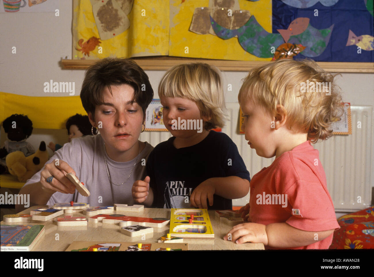creche worker playing with children Stock Photo - Alamy