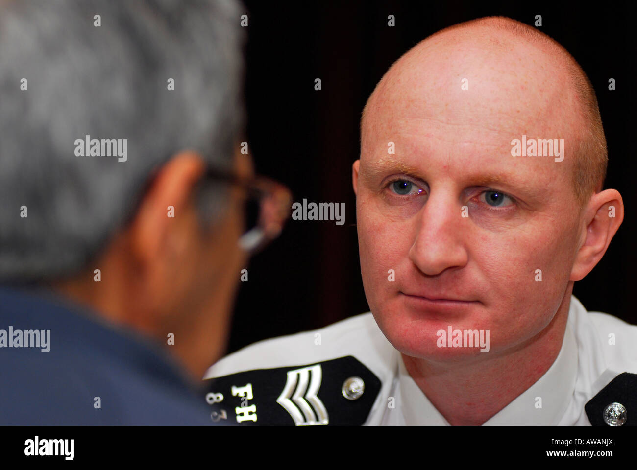 Police officer listening to views of a member of the public at a crime ...