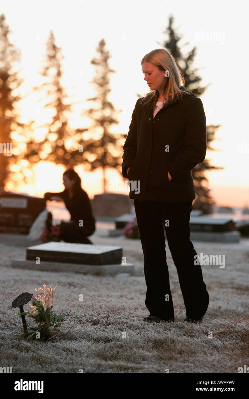 Women visiting grave in cemetery Stock Photo - Alamy