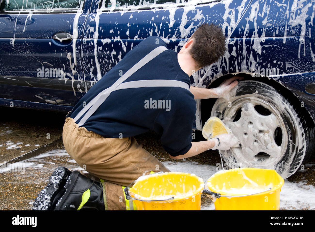 fireman washing car for charity, sussex england uk Stock Photo - Alamy