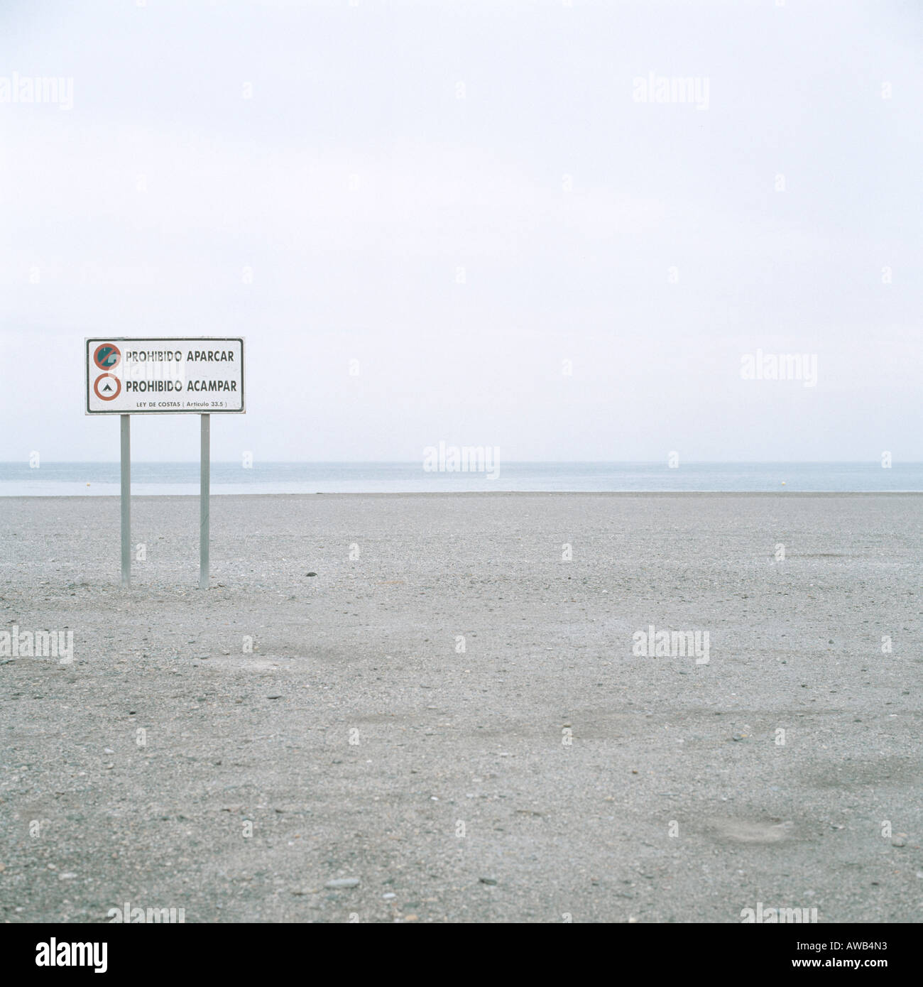 no parking and no camping on the beach sign on empty pebblestone beach ...