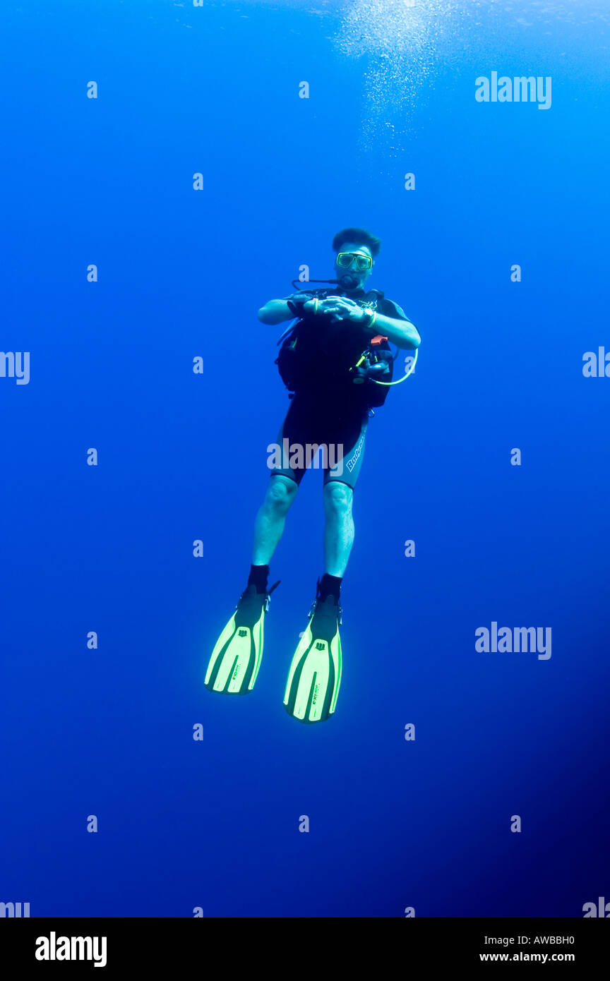 Chris Sly. Diver relaxing in mid water hover with deep blue ocean ...