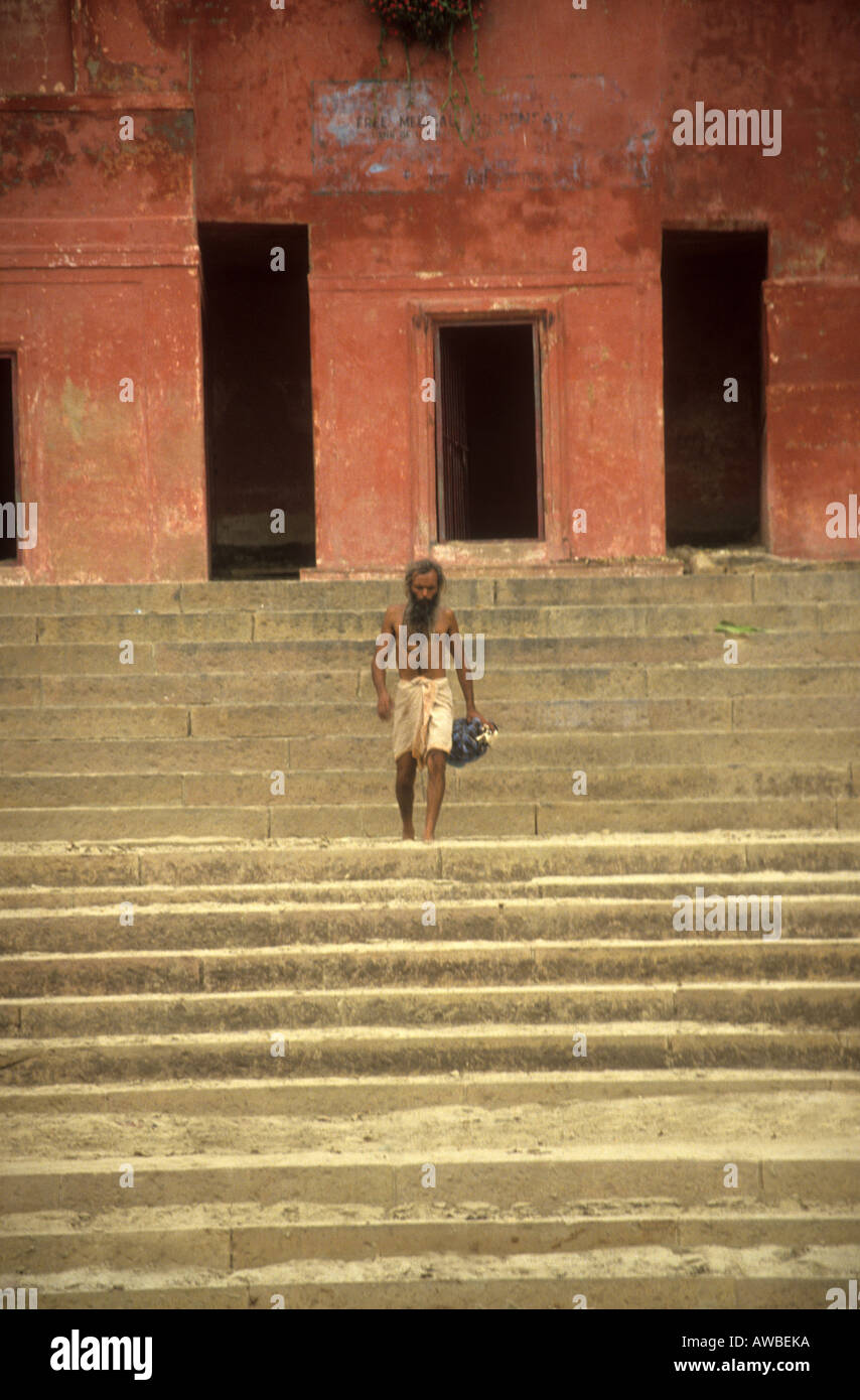 Man descending stairs at a bathing Ghat on the banks of the holy river ...