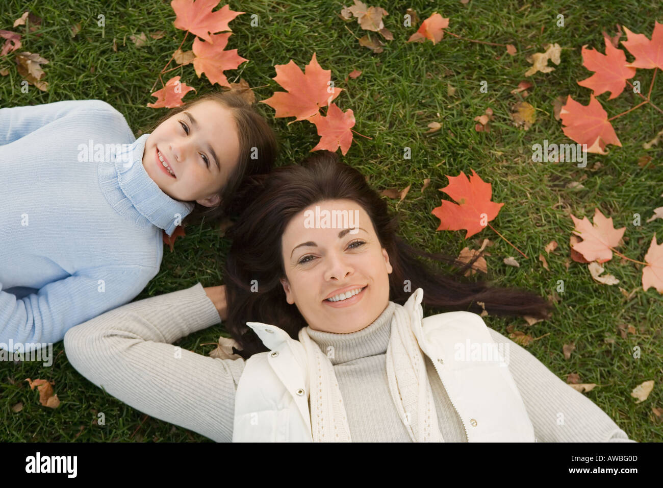 Mother and daughter lying on grass on fall day Stock Photo - Alamy