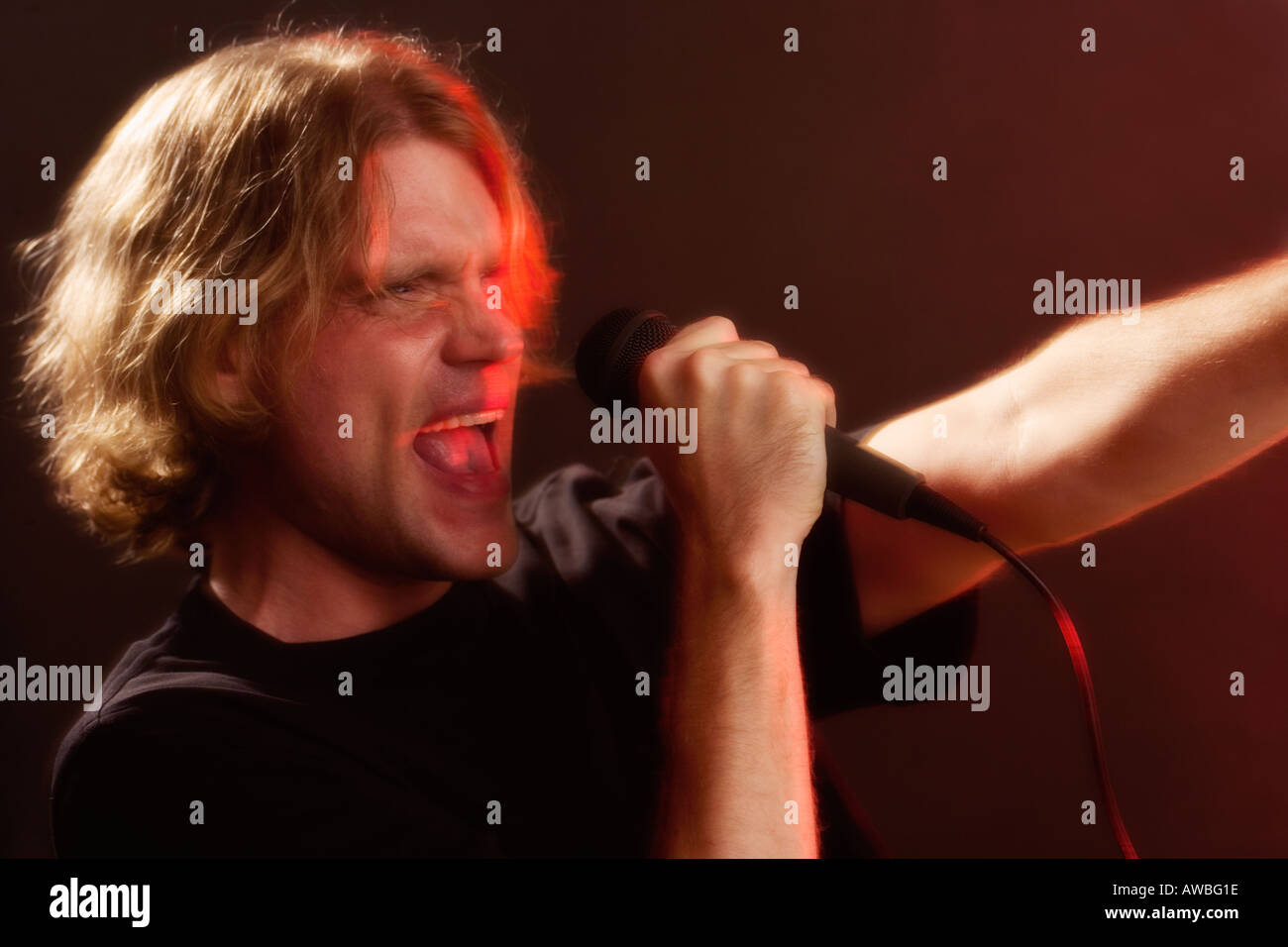 Man singing into microphone Stock Photo - Alamy
