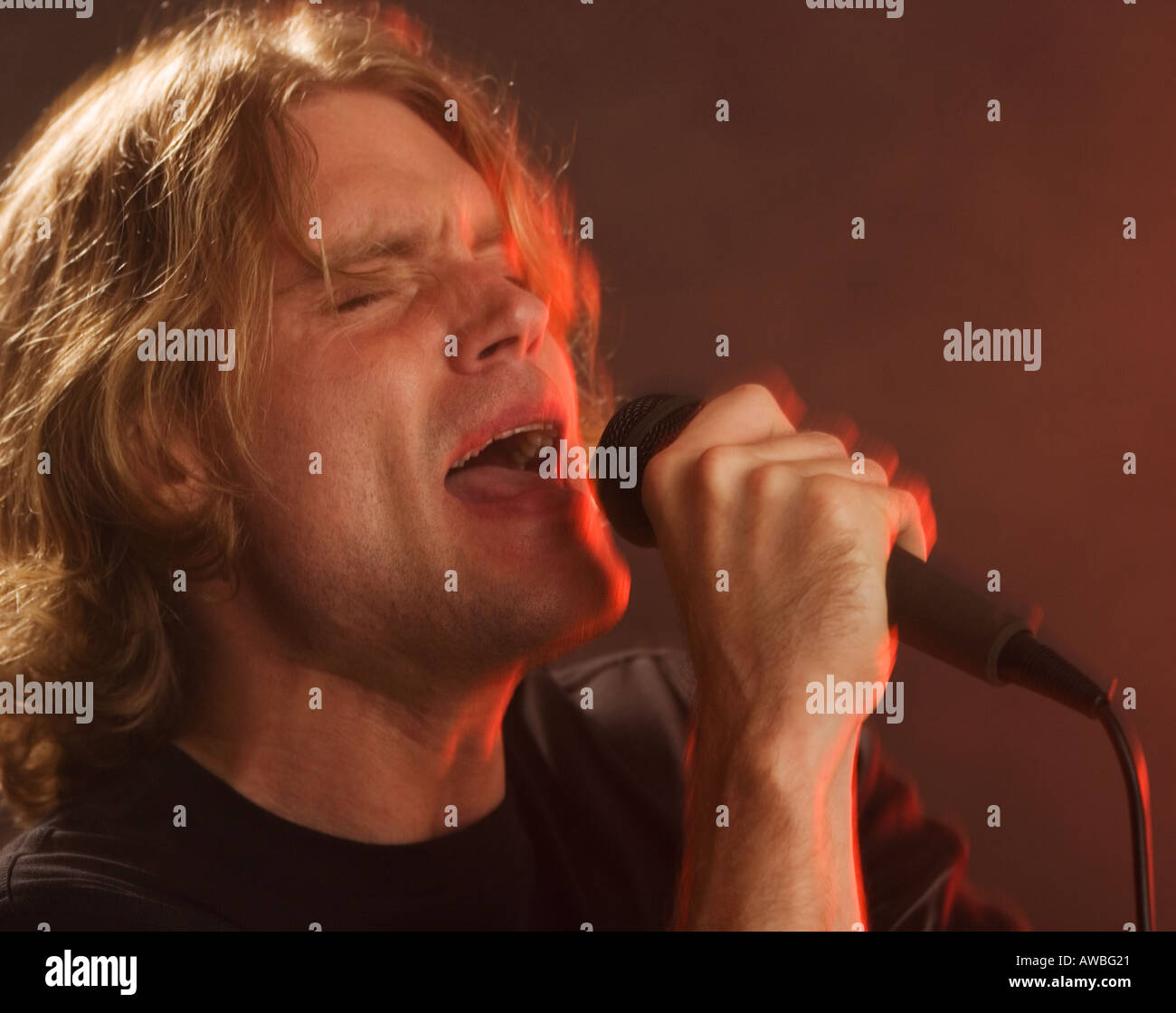 Man singing into microphone Stock Photo - Alamy