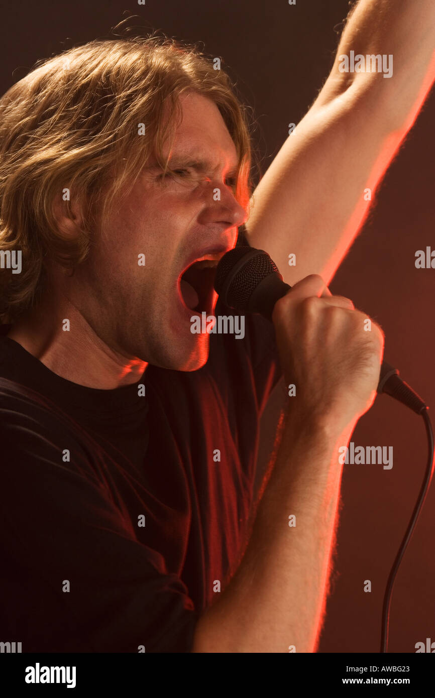 Man singing into microphone Stock Photo - Alamy