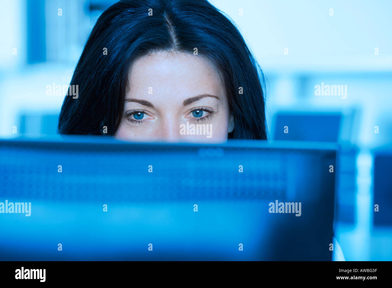 Woman in office looking at computer screen Stock Photo - Alamy