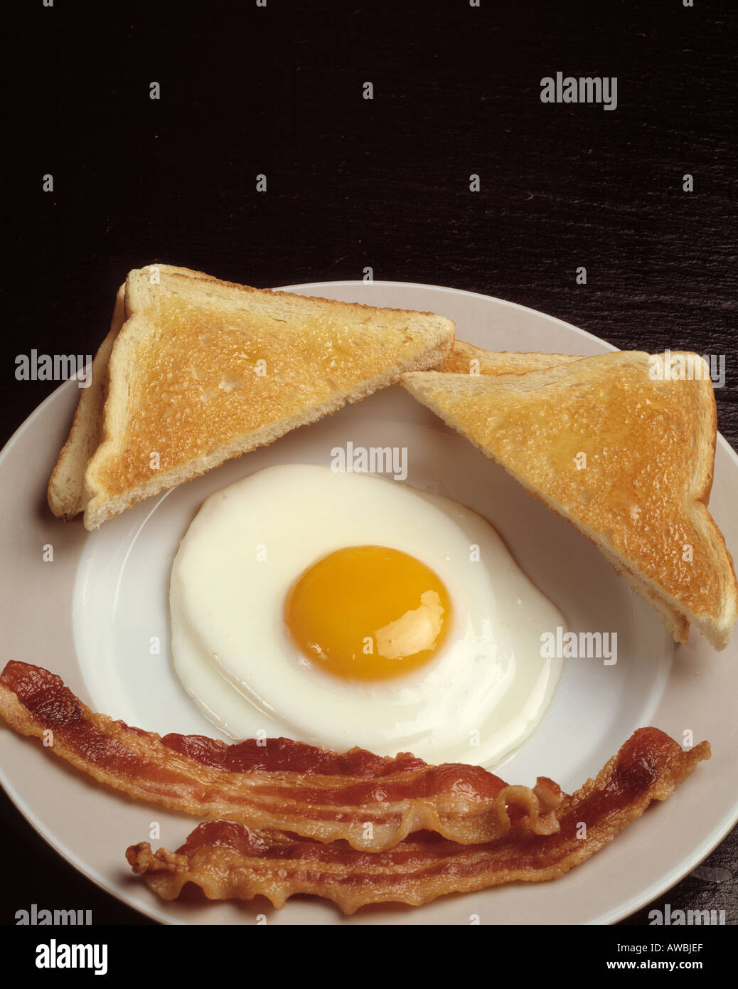 breakfast plate one fried egg sunny side up two slice bacon toast on ...