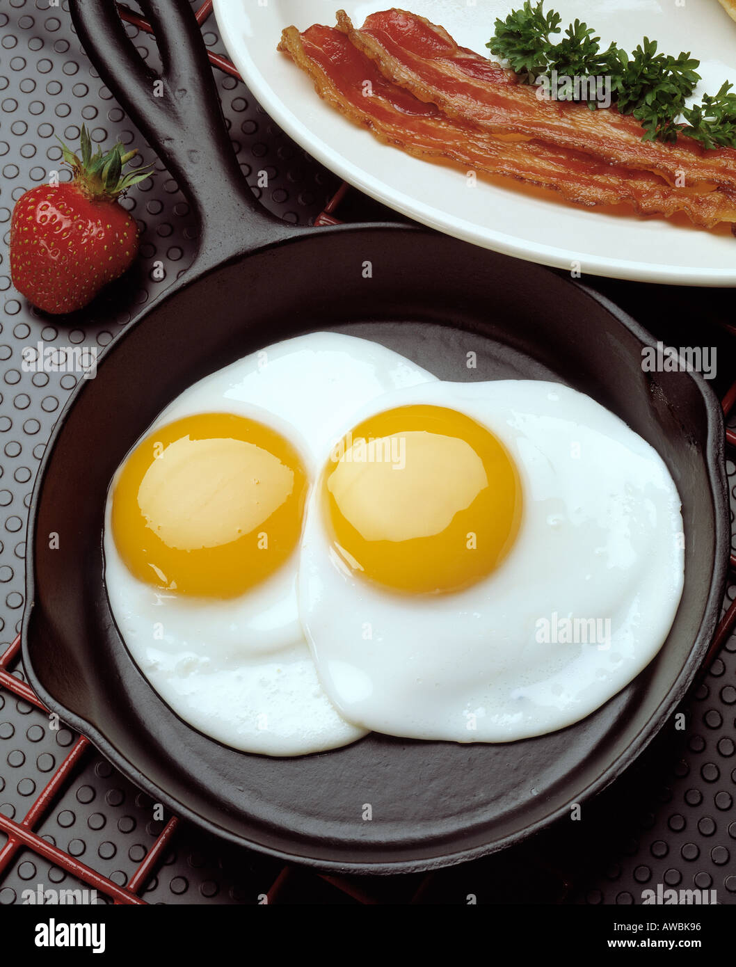 breakfast two fried eggs black cast iron fry frying pan sunny side up ...