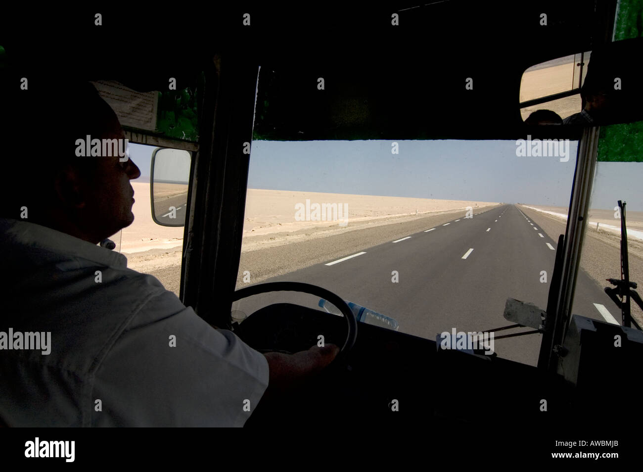Man driving a public bus on a desert Sahara road, photo taken in South ...
