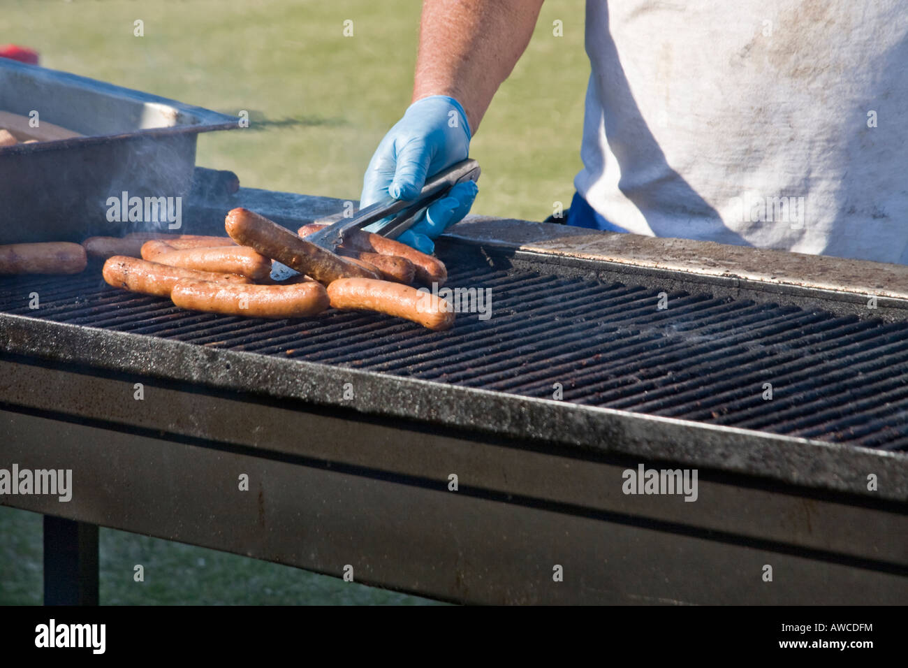 A close-up of a man grilling hot dogs on a barbecue Stock Photo - Alamy