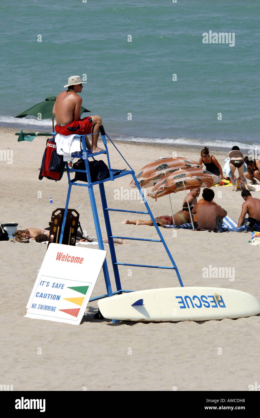 A Beach Lifeguard sitting in a tower keeping a watchful eye on bathers ...