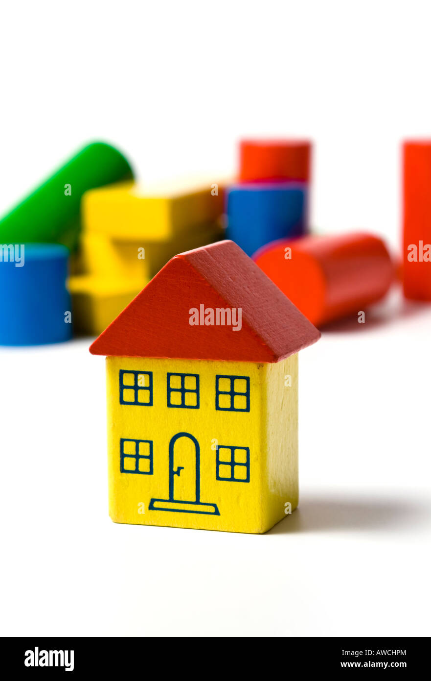 little house built of building blocks, more blocks in background, white ...