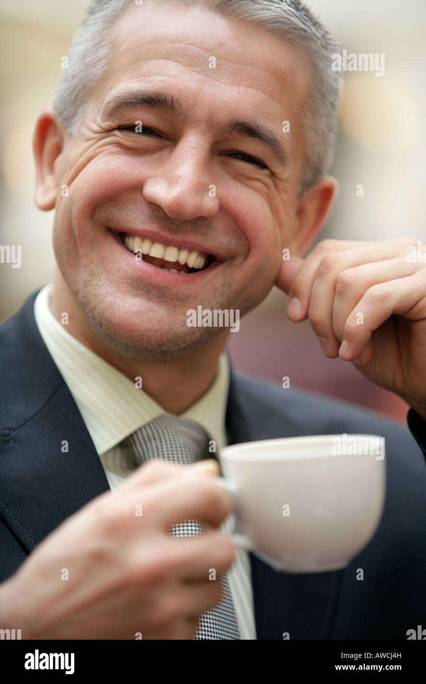 Portrait of smiling man holding a cup of tea Stock Photo - Alamy