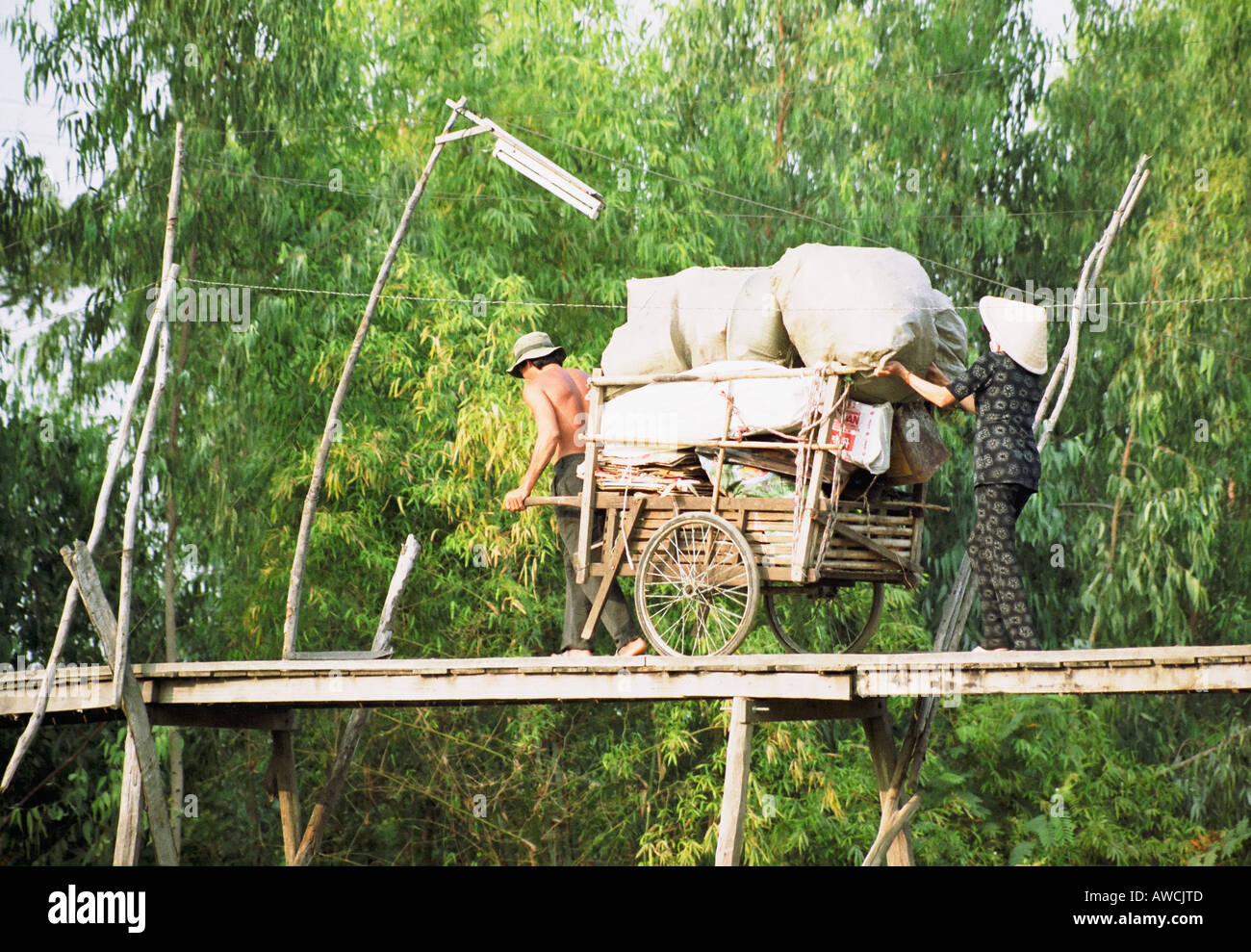 Man Pulling Cart Across Footbridge Stock Photo - Alamy