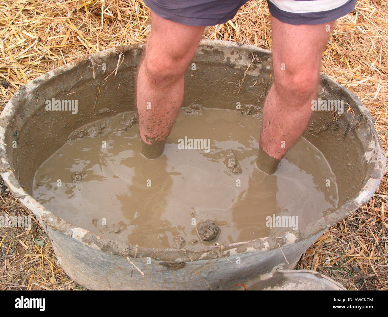 Forty-year-old man standing with both legs in a vat of mud Stock Photo ...