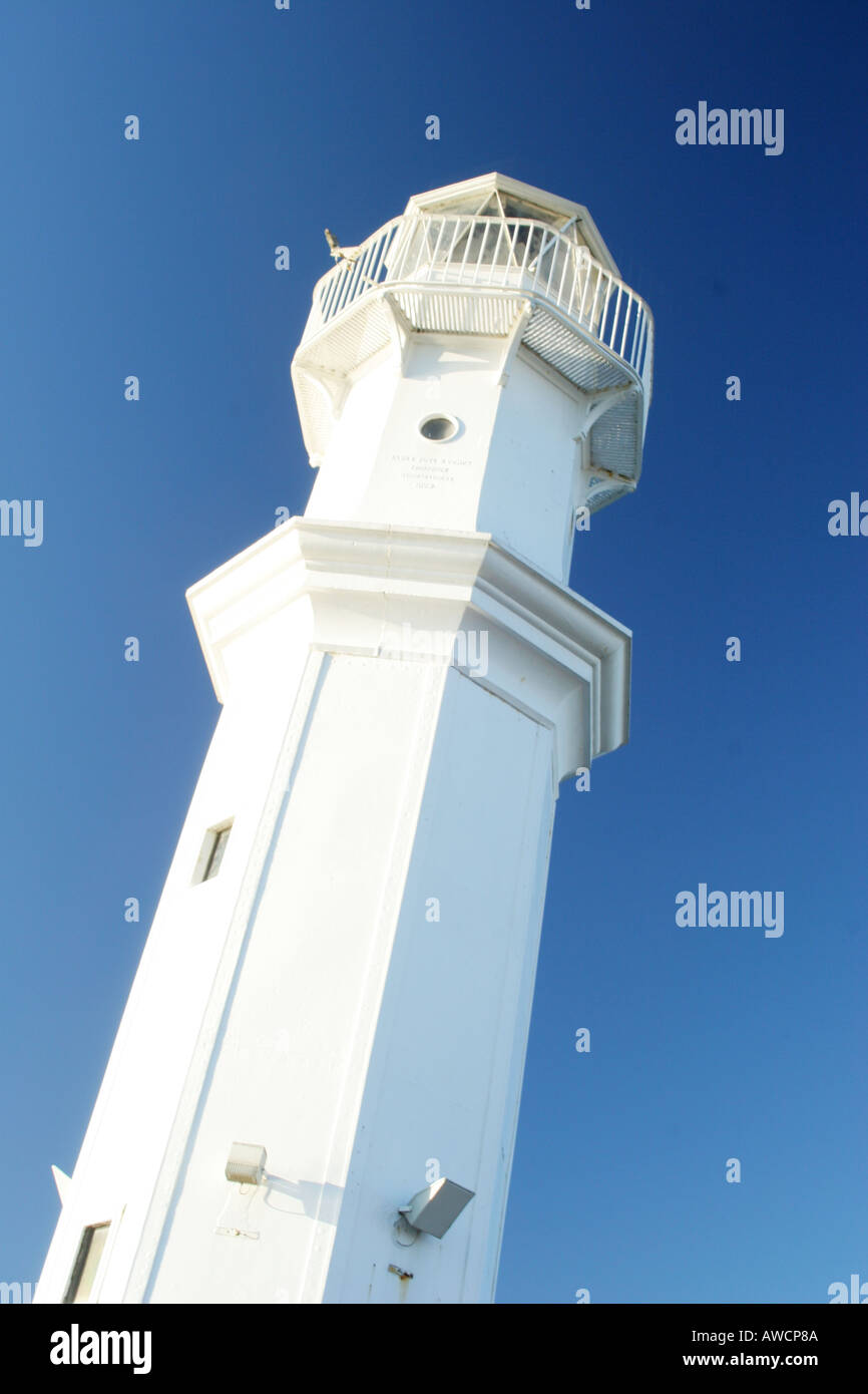 Bright White cast iron lighthouse towering into a deep blue sky ...