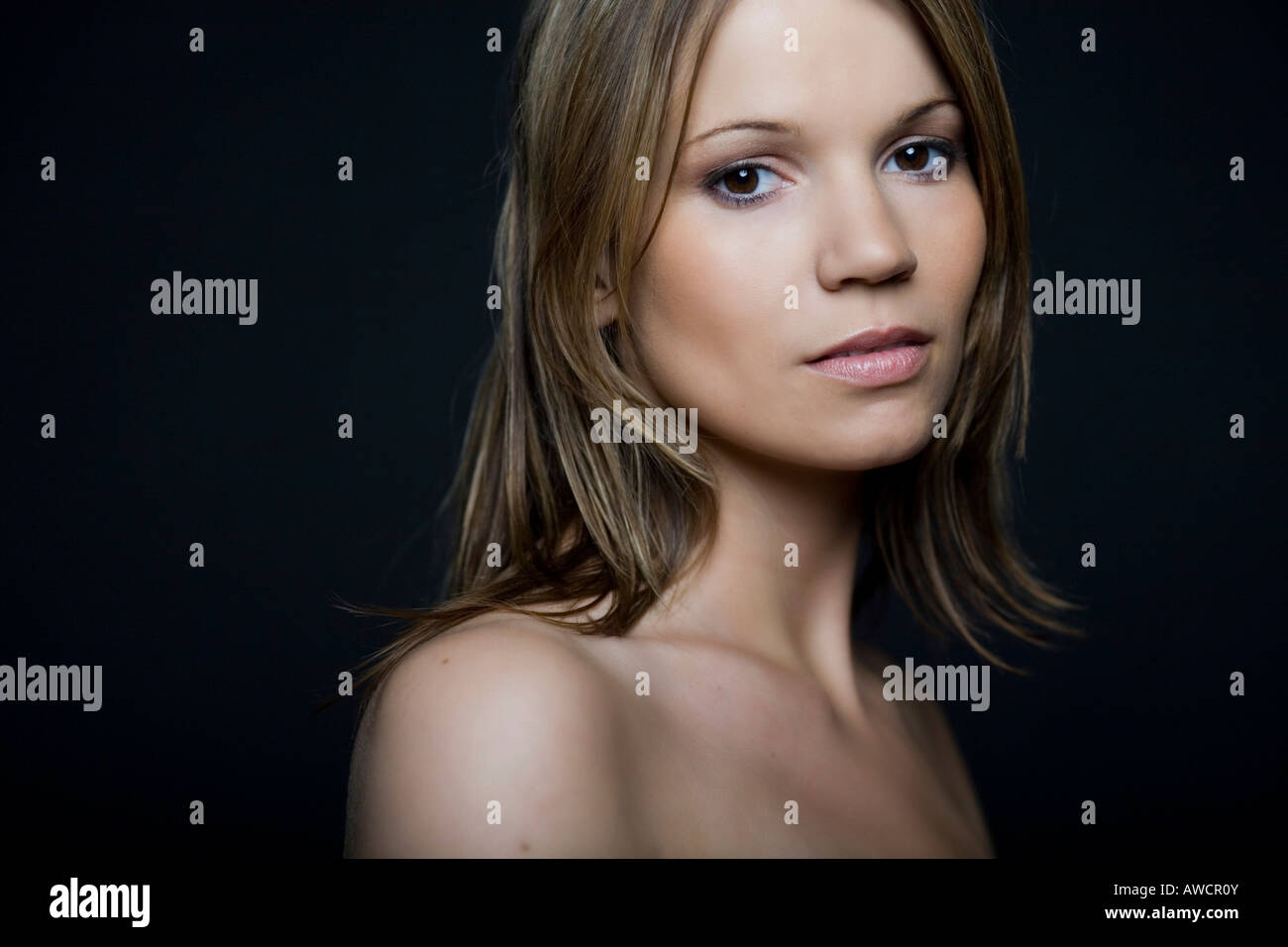 Woman looking into the camera, portrait in front of black Stock Photo ...