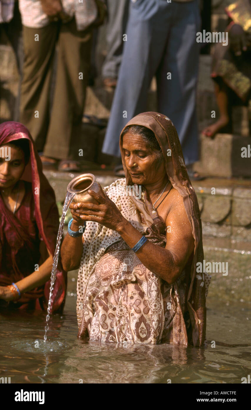 Woman at prayer in the river Ganges at Varanasi during the Kartik ...