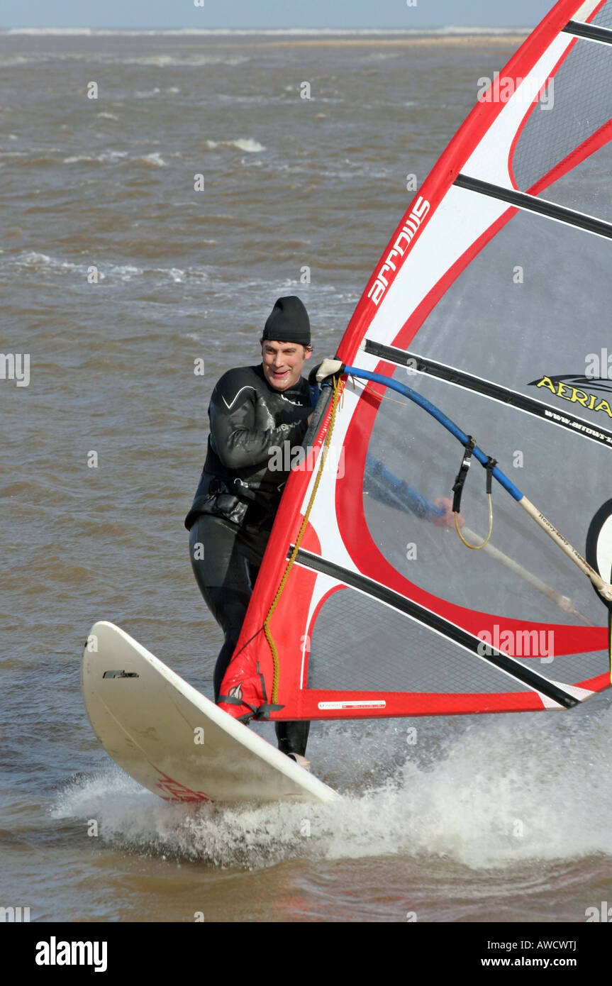 Windsurfer with a red sail racing over the waves Stock Photo - Alamy