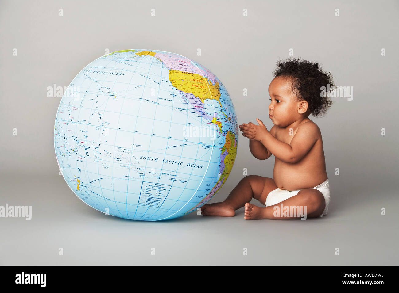 Baby Looking at Globe Stock Photo - Alamy